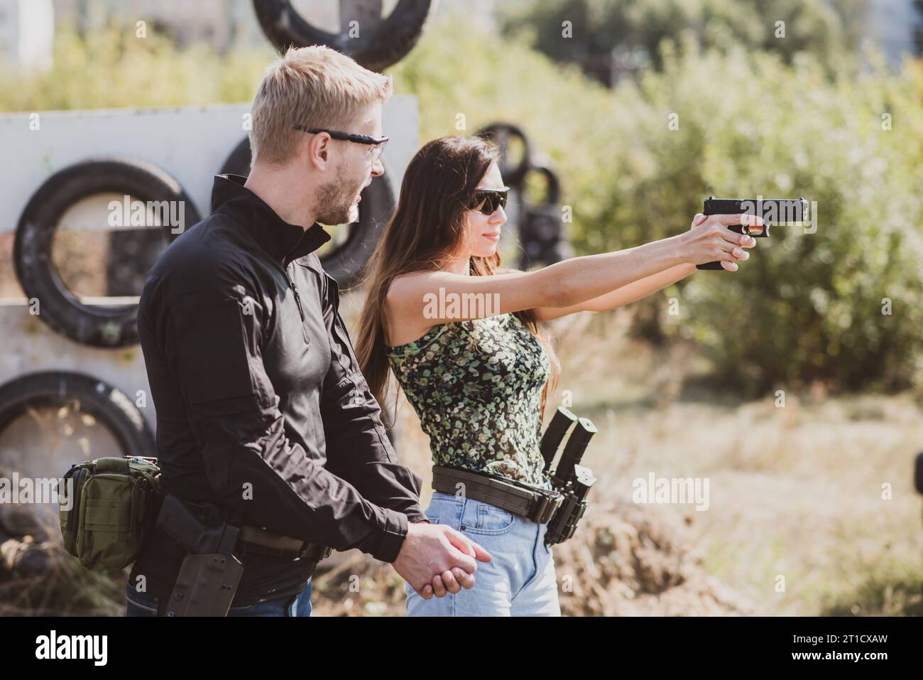 Shooting instructor teaching a woman how to properly handle a weapon at ...