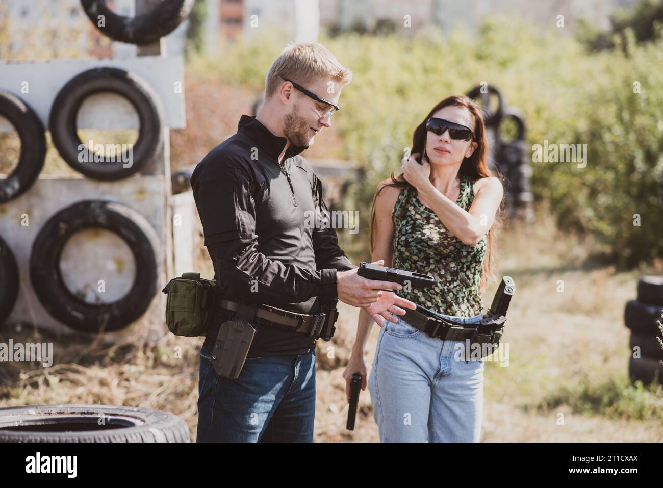 Shooting instructor teaching a woman how to properly handle a weapon at ...