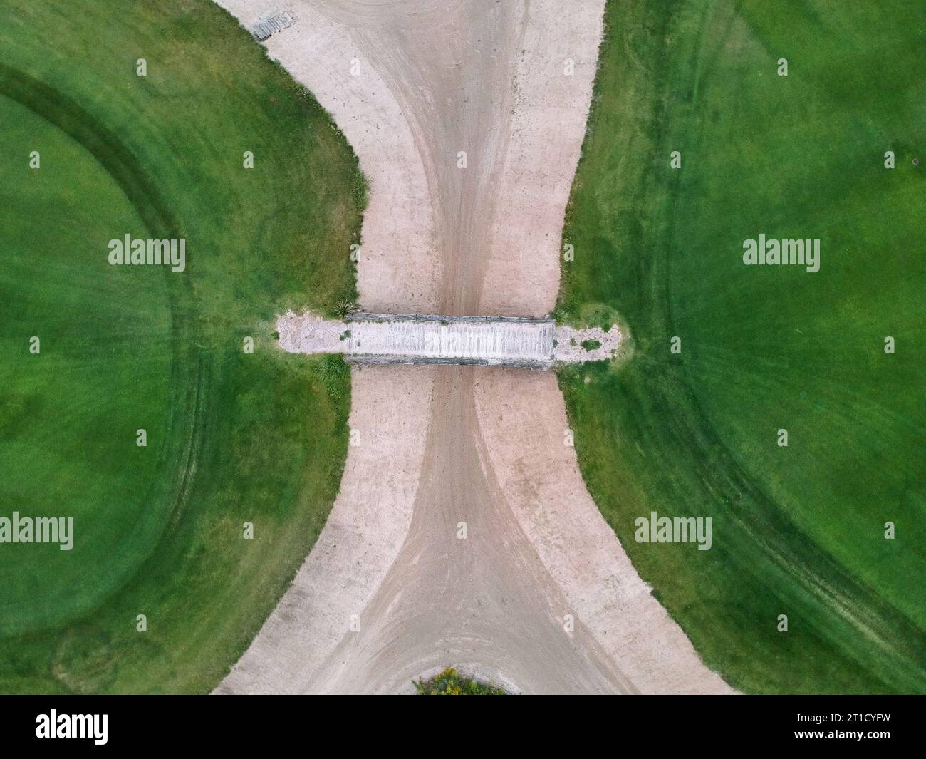 Aerial view of the green grass of the golf course. Bridge between hills ...