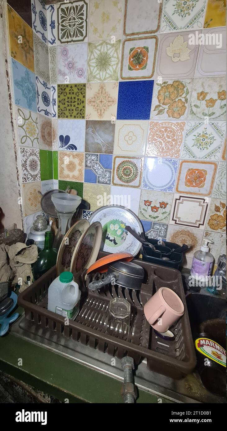 The kitchen still has dished drying on the rack and a washed out milk ...