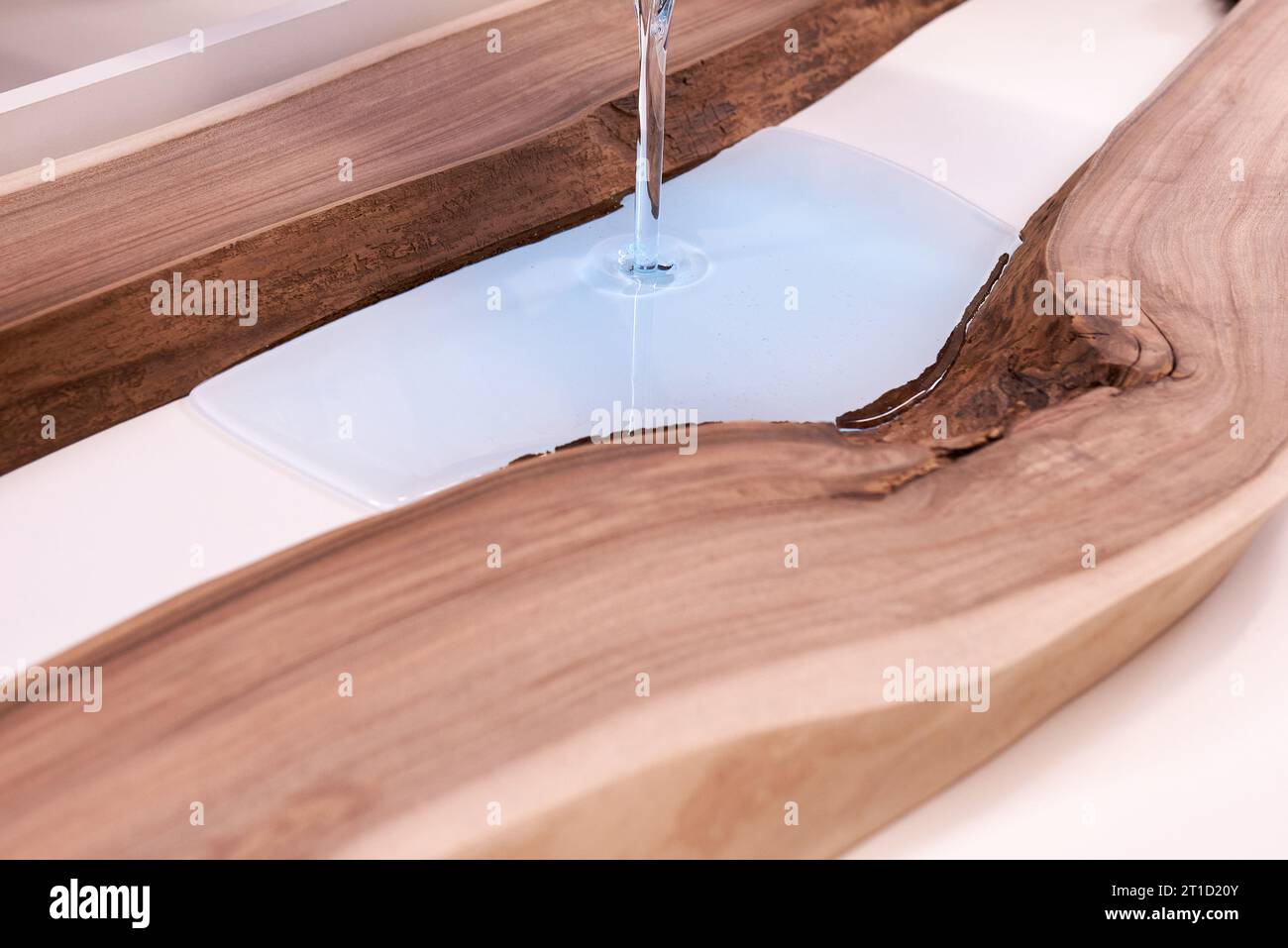Process making of a craft resin and wood table. Liquid epoxy is poured ...