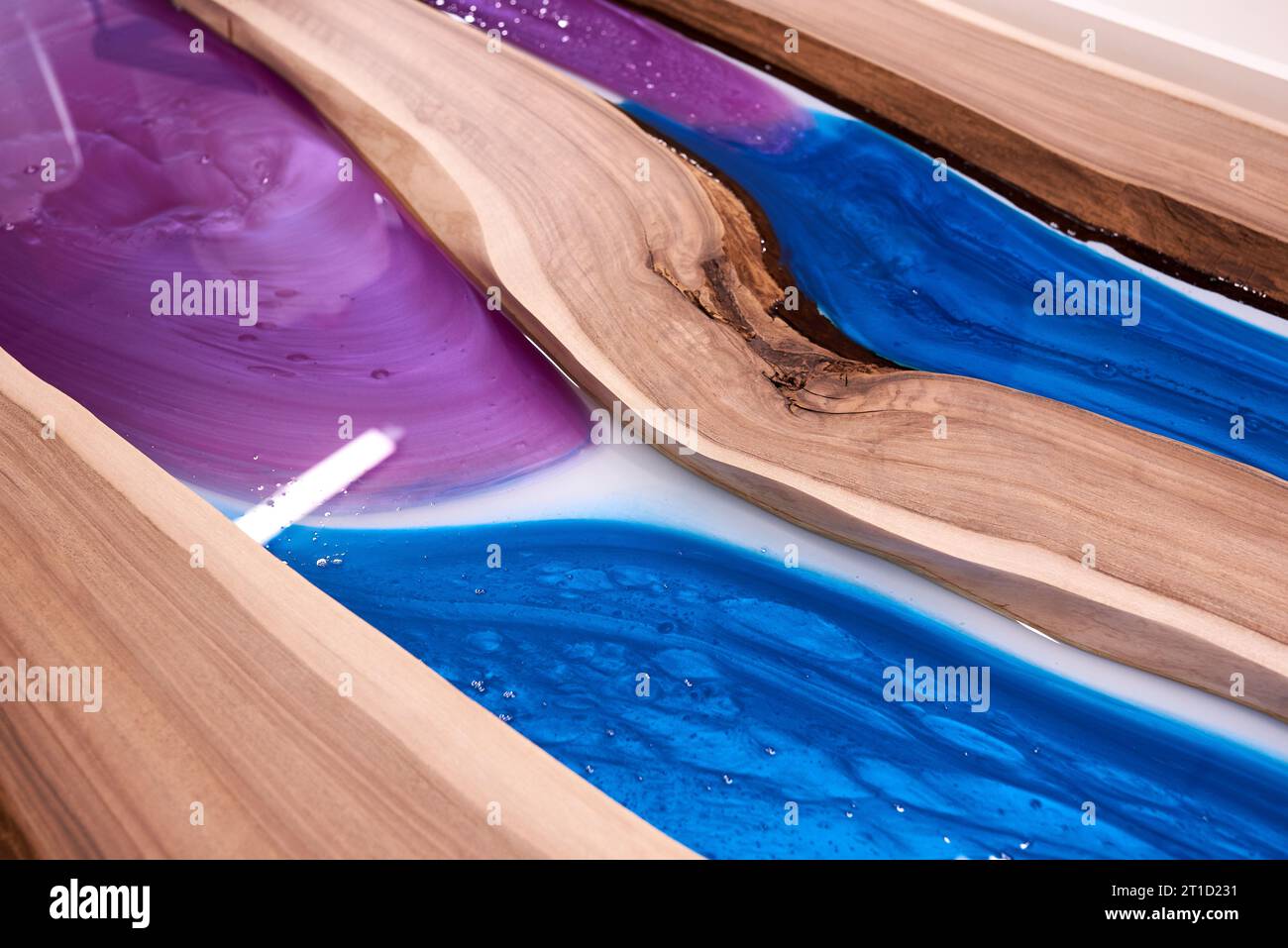 Process making of a craft resin and wood table. Liquid epoxy is poured ...