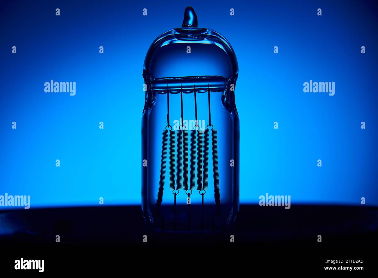 Extinguished electric vintage Edison light bulb with a spiral on a blue ...