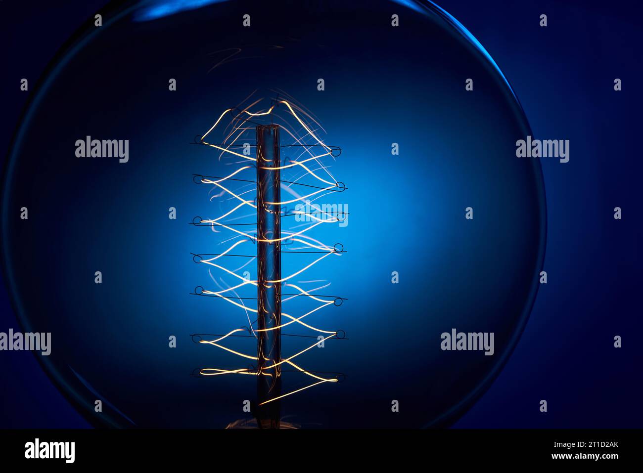 Electric vintage Edison light bulb with a spiral on a blue background ...