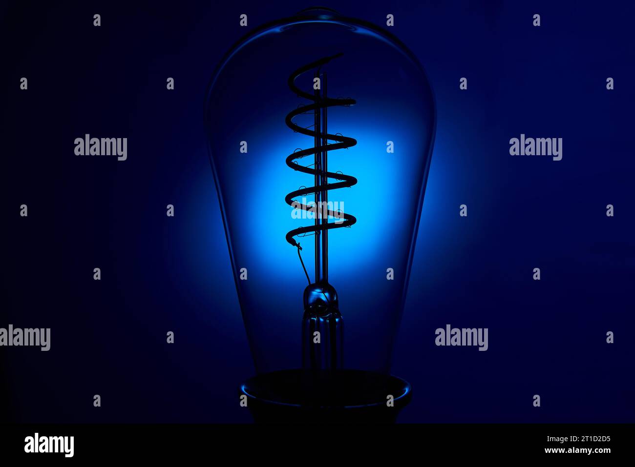 Electric vintage Edison light bulb with a spiral on a blue background ...