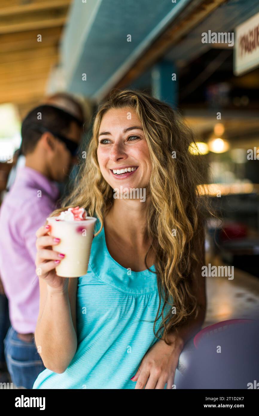 A beautiful woman enjoys a pina colada at a dive bar in Puerto Rico ...