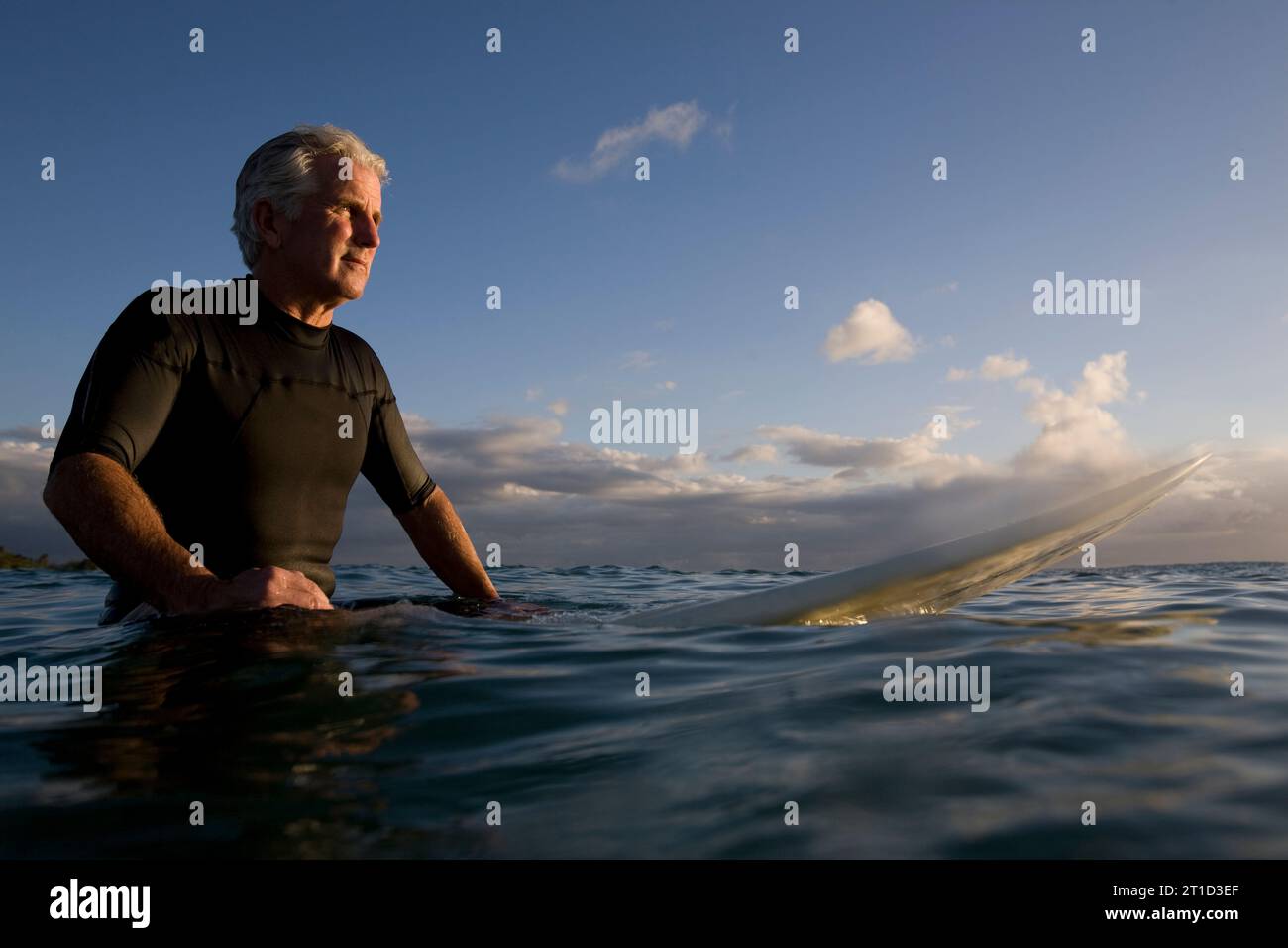 senior surfer sitting on his surfboard Stock Photo - Alamy
