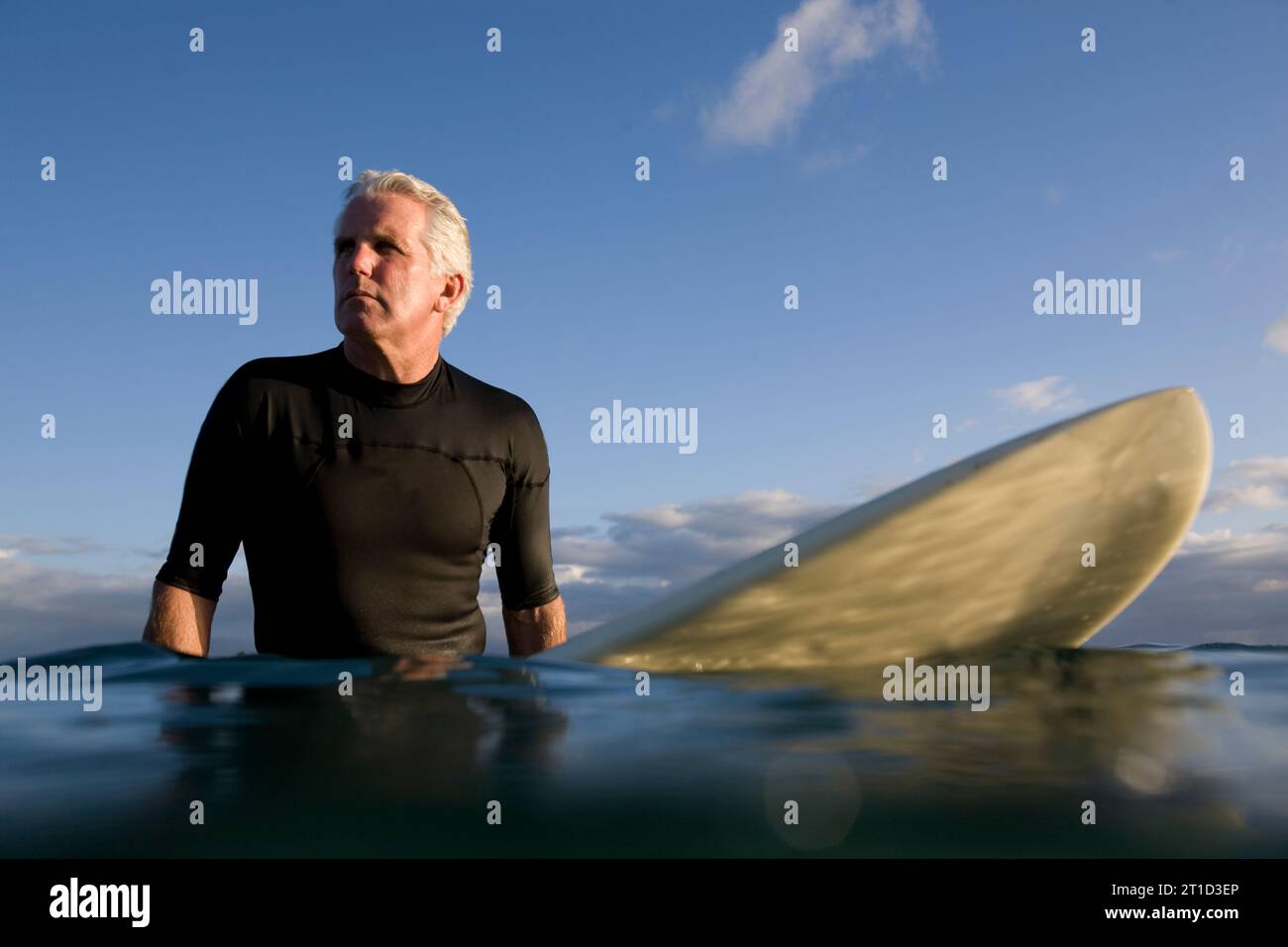 senior surfer sitting on his surfboard Stock Photo - Alamy