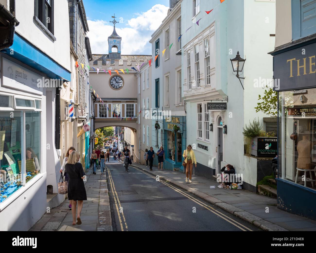 People walk near the 14th century East Gate Arch with its large clock ...