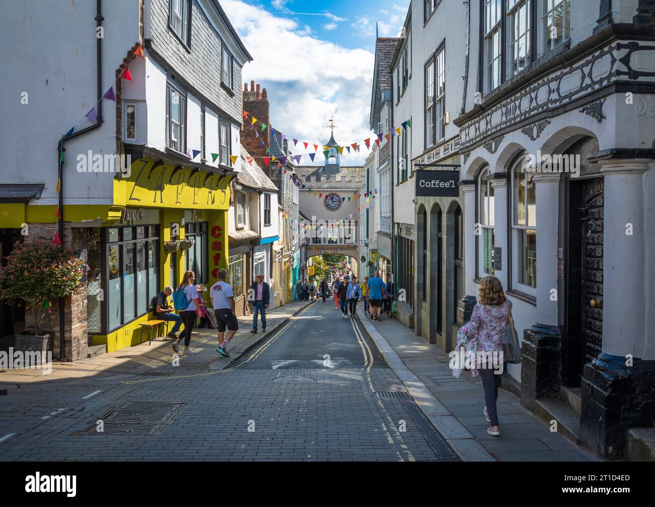 People walk near the 14th century East Gate Arch with its large clock ...