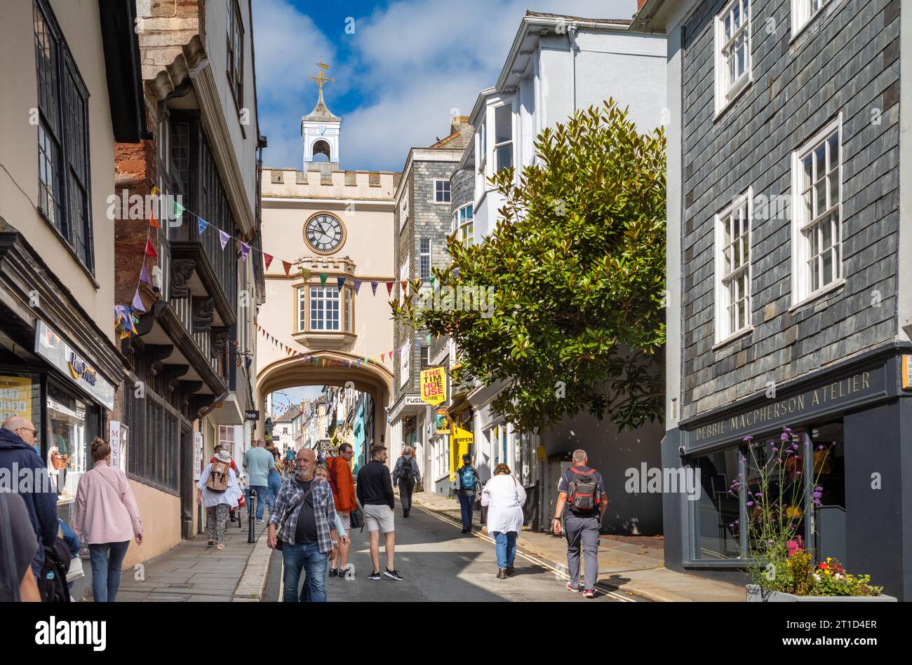 People walk near the 14th century East Gate Arch with its large clock ...