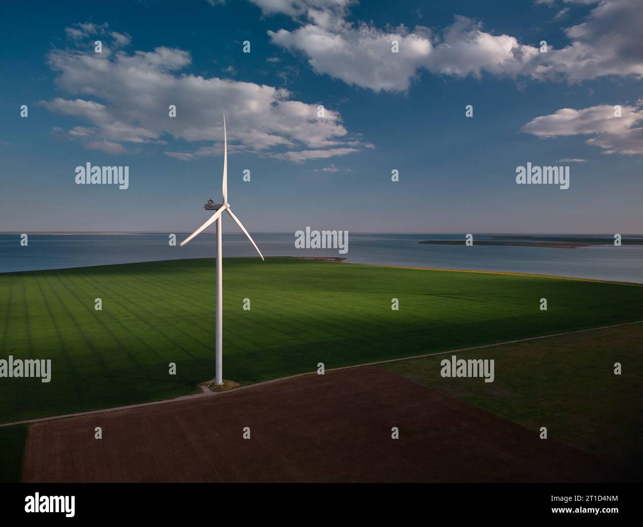Aerial top view of wind turbines and agriculture field near the sea at ...