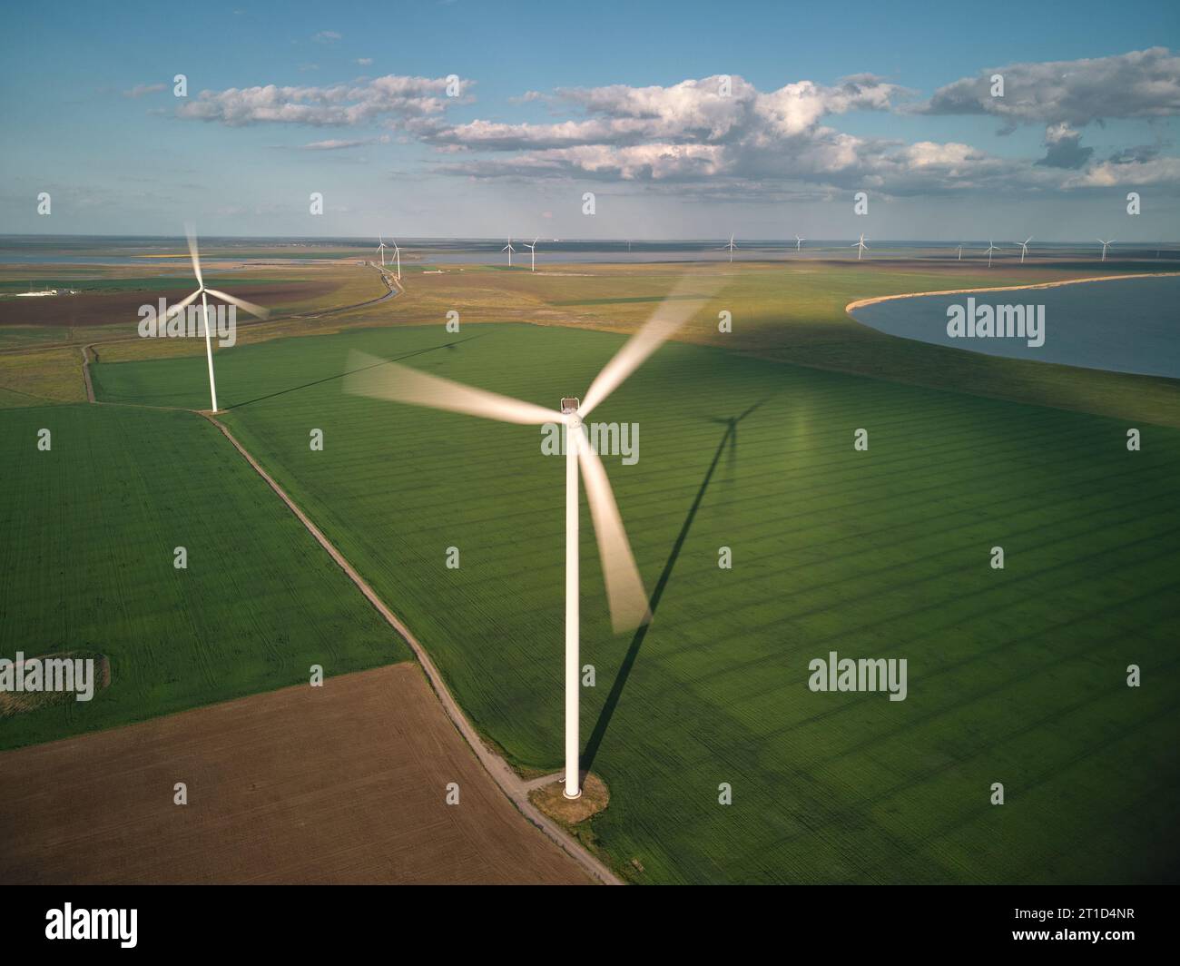 Aerial top view of wind turbines and agriculture field near the sea at ...