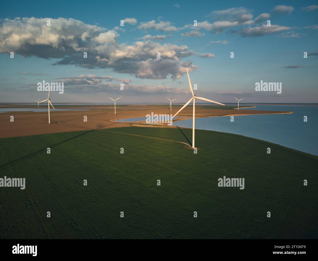 Aerial top view of wind turbines and agriculture field near the sea at ...