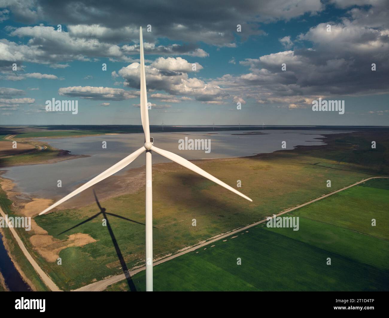 Aerial top view of wind turbines and agriculture field near the sea at ...