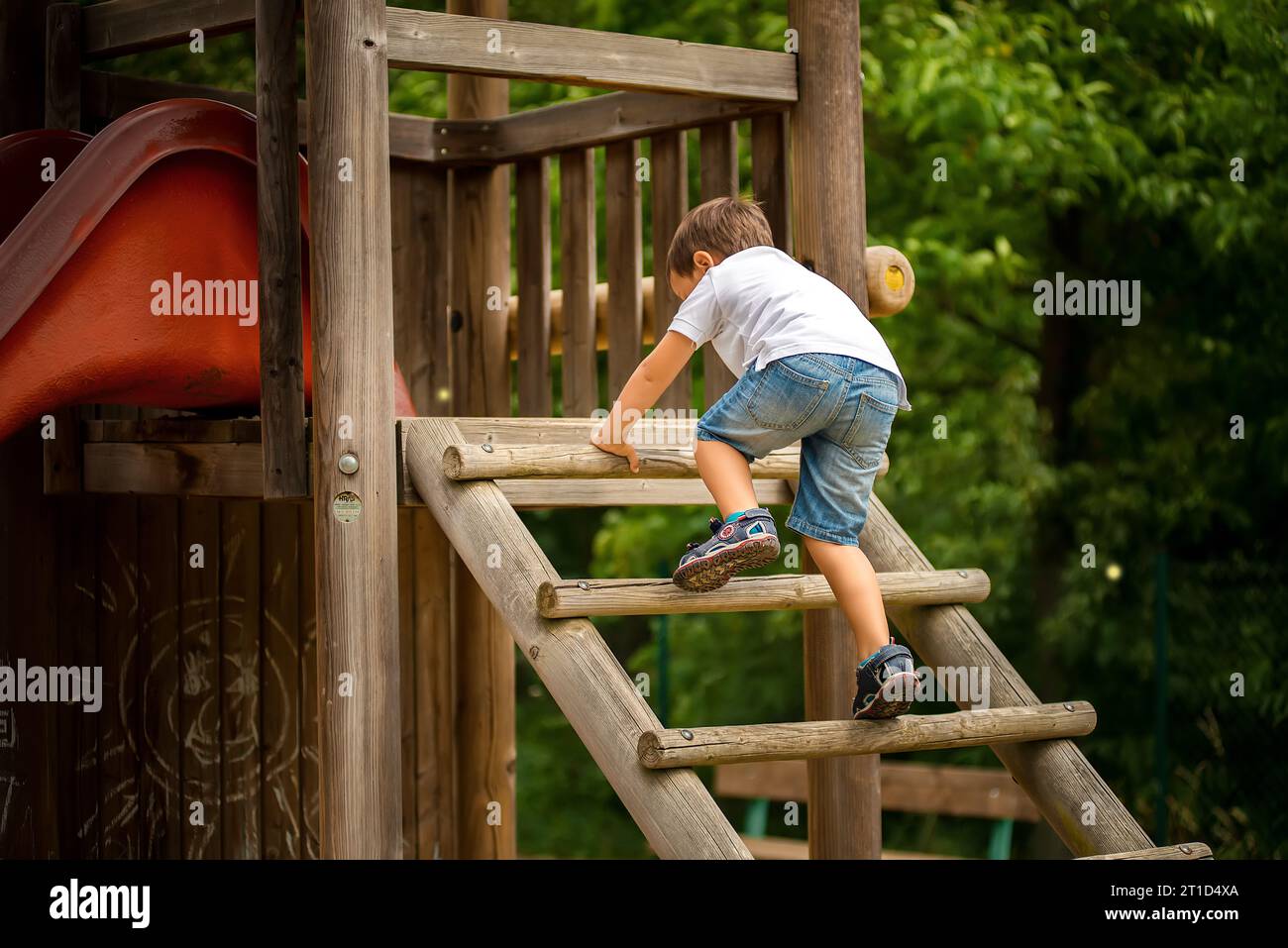 Little boy climbing on a wooden ladder in a children's playground Stock ...