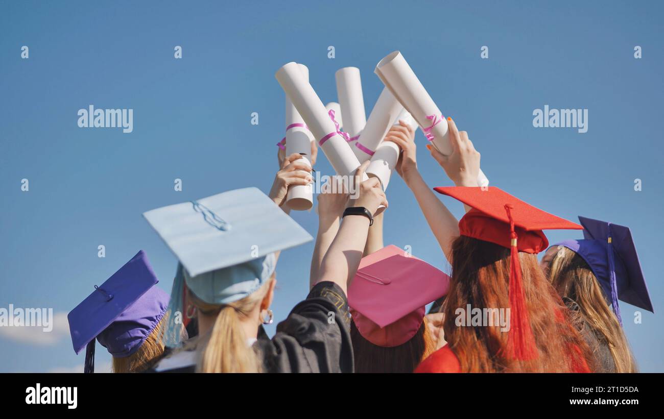 Graduates raise up their diplomas standing together Stock Photo - Alamy