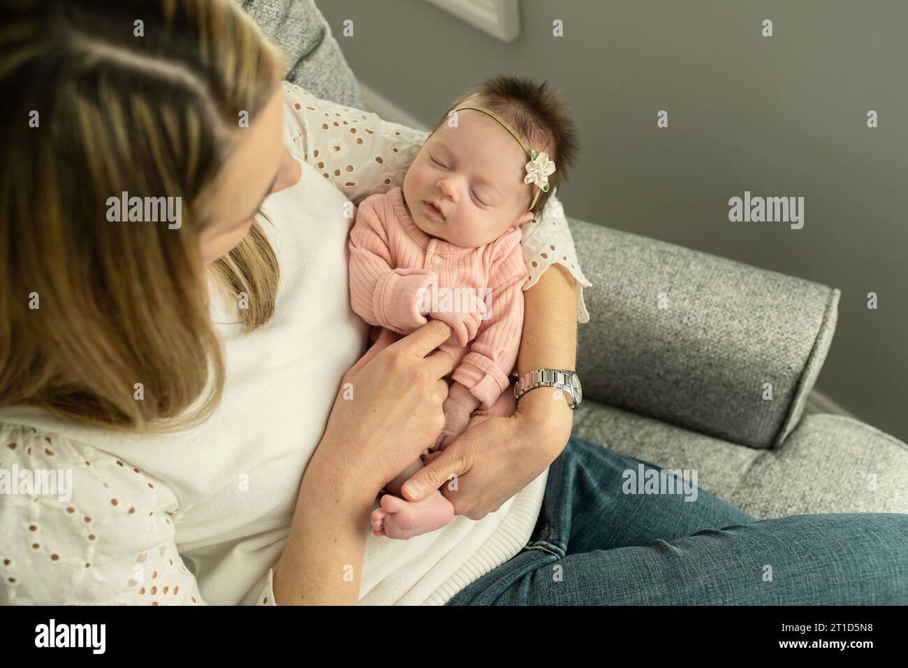 Close up overhead image of mother holding newborn; grabbing finger ...