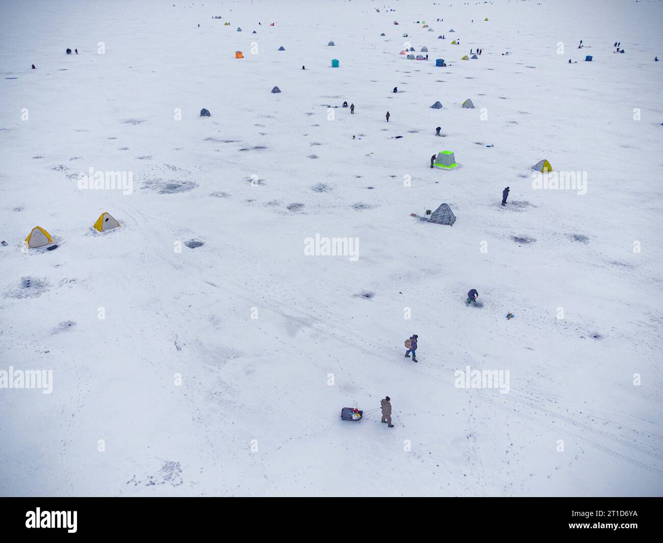 Winter fishing on a frozen lake. Colorful fishing tents mounted on ice ...