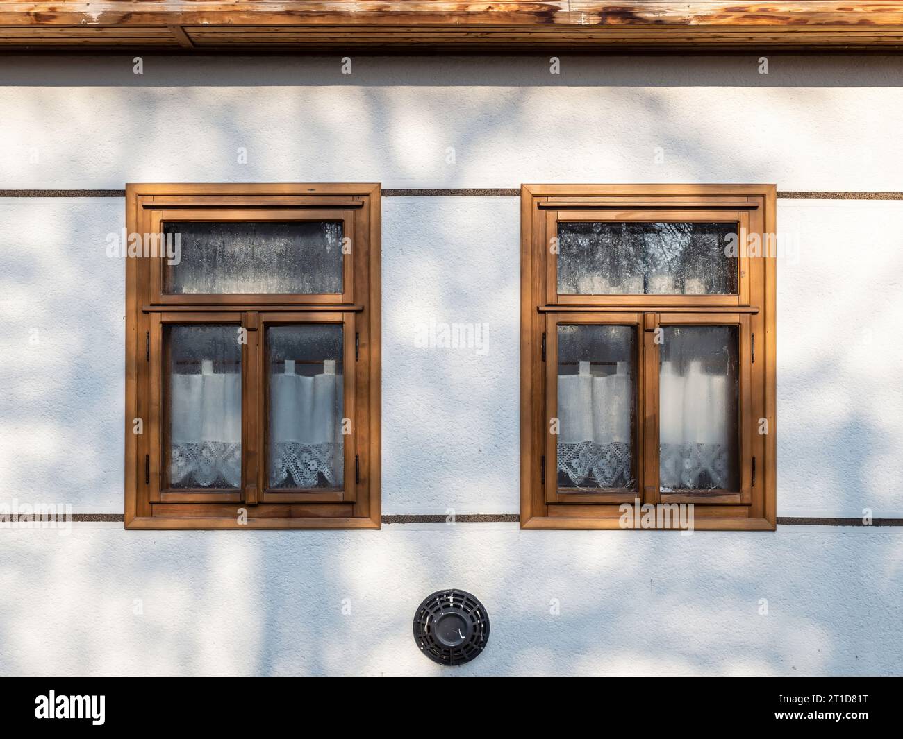 Traditional wooden framed windows and handmade curtains in a village in ...