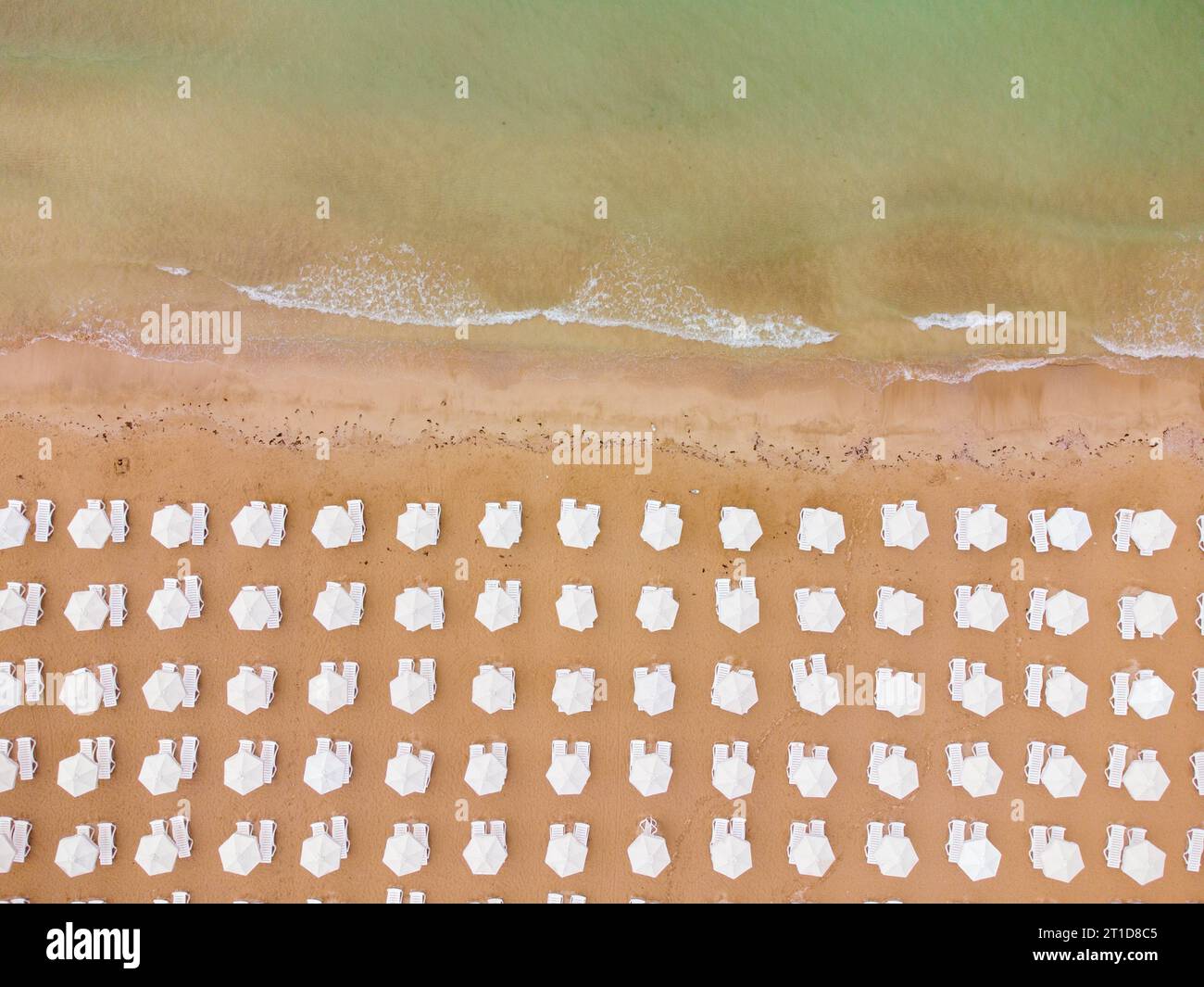 Aerial top view of an amazing empty beach with white beach umbrellas ...