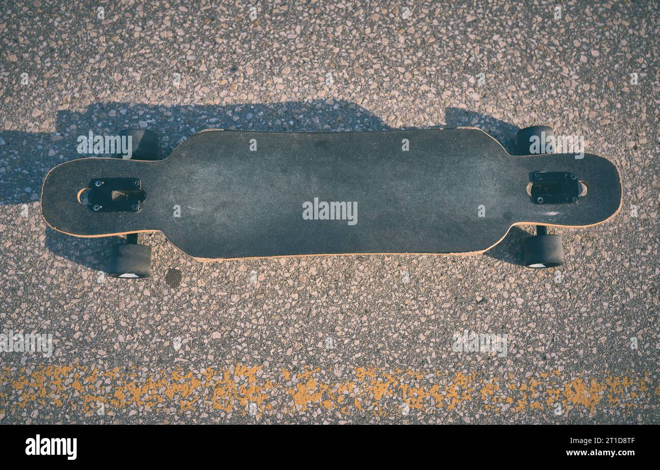 double kick cutaway longboard on asphalt without people, evening photo ...