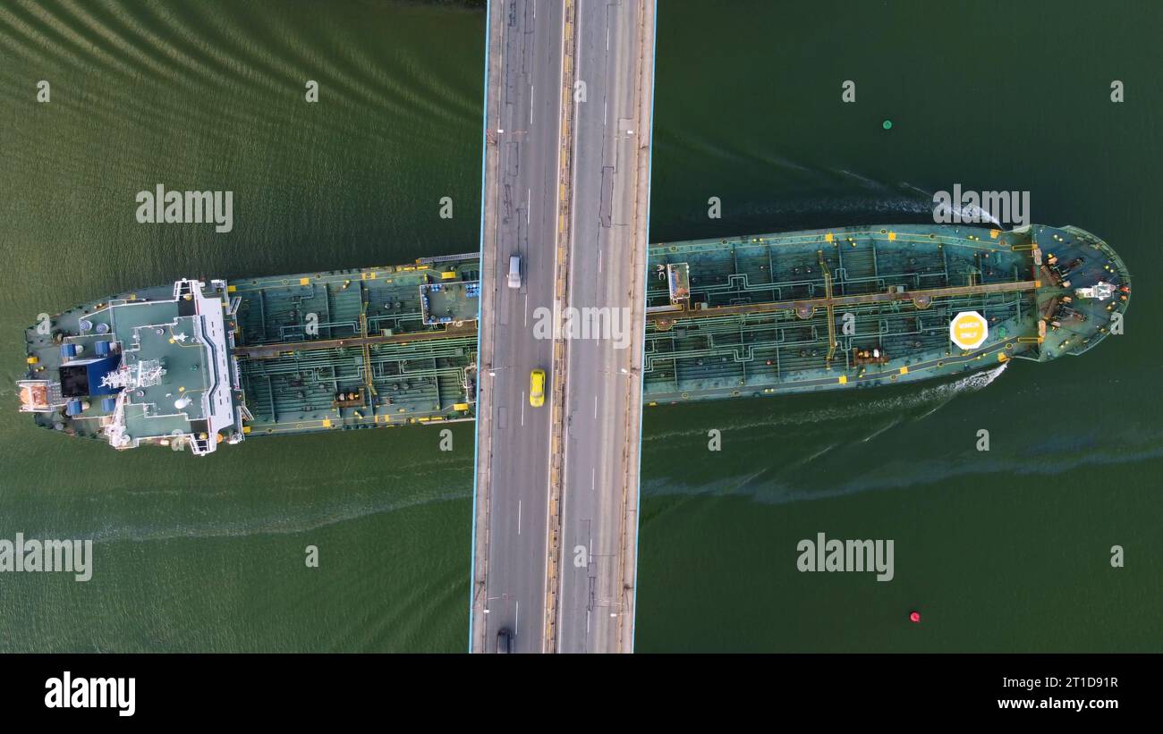 Large general cargo ship tanker bulk carrier passing under a bridge ...