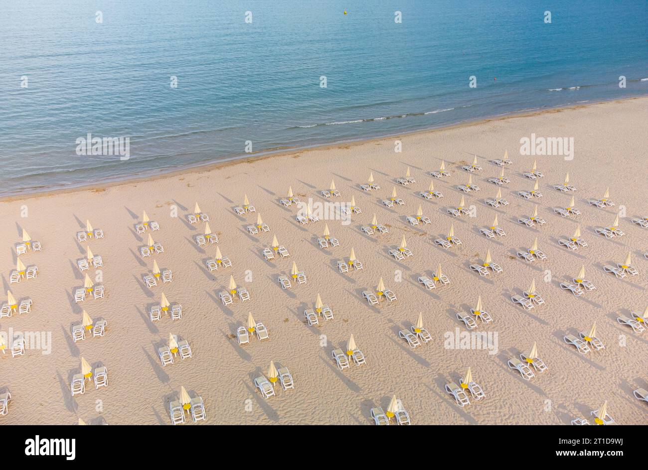 Aerial top view of an amazing empty sandy beach with beach umbrellas ...