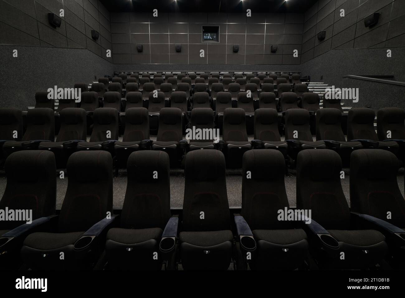 Empty cinema hall with black seats and walls. Movie theatre nobody ...