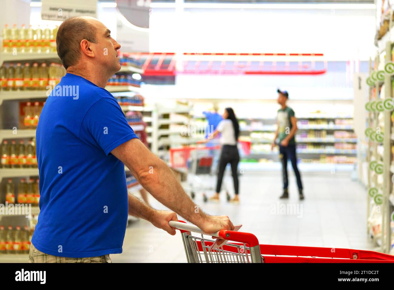 Men in the supermarket. The male with cart in shopping mall. The ...