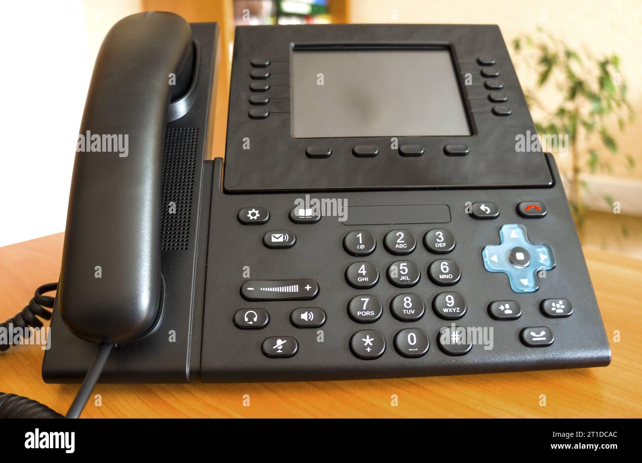 The black desktop push-button telephone. IP phone on desk in office ...
