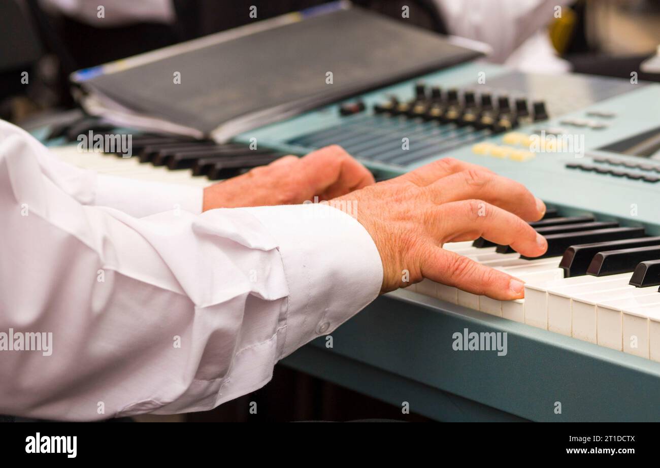 Pianist playing piano.Hands over piano in warm tones.The man plays the ...