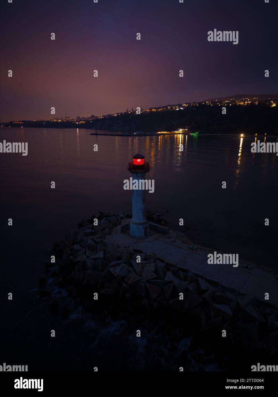 lighthouse on the seashore with red light at night against the ...