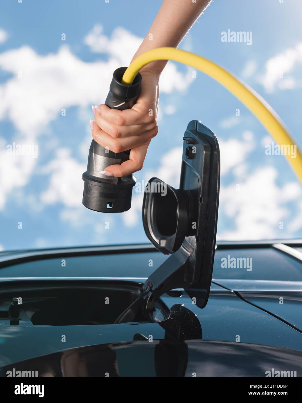 Female hand charging electric car with blue sky, photo from below Stock ...