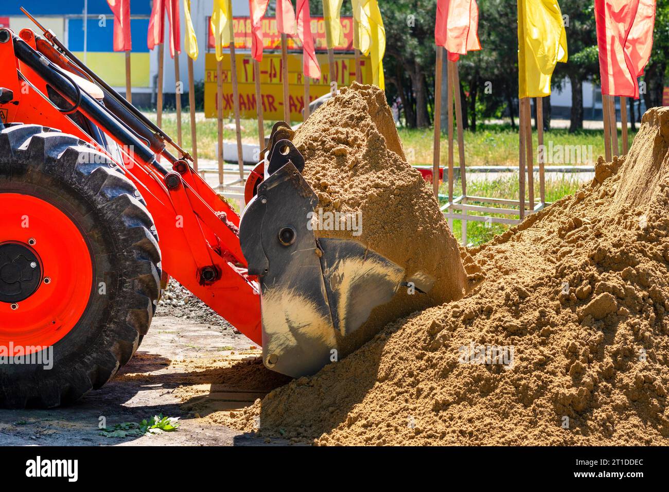The tractor is rowing sand. Excavator bucket with sand. Road ...