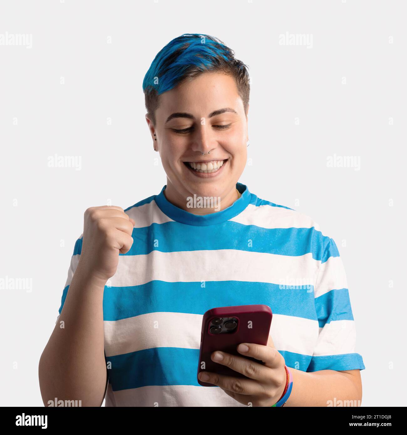 Non-binary individual with vibrant blue hair celebrates receiving a ...
