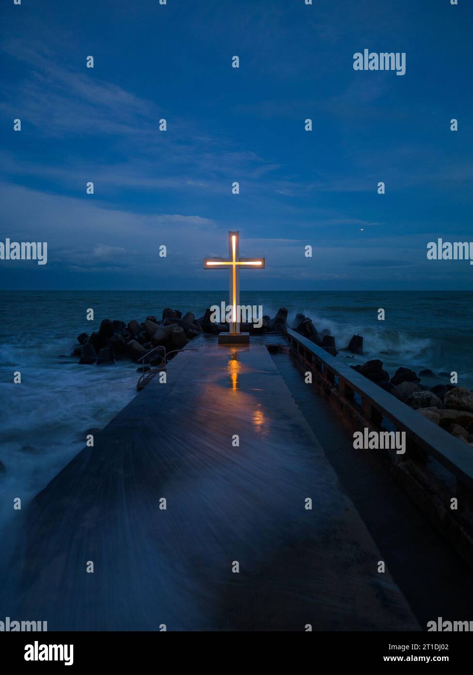 christian cross standing on pier in the stormy sea or ocean with ...
