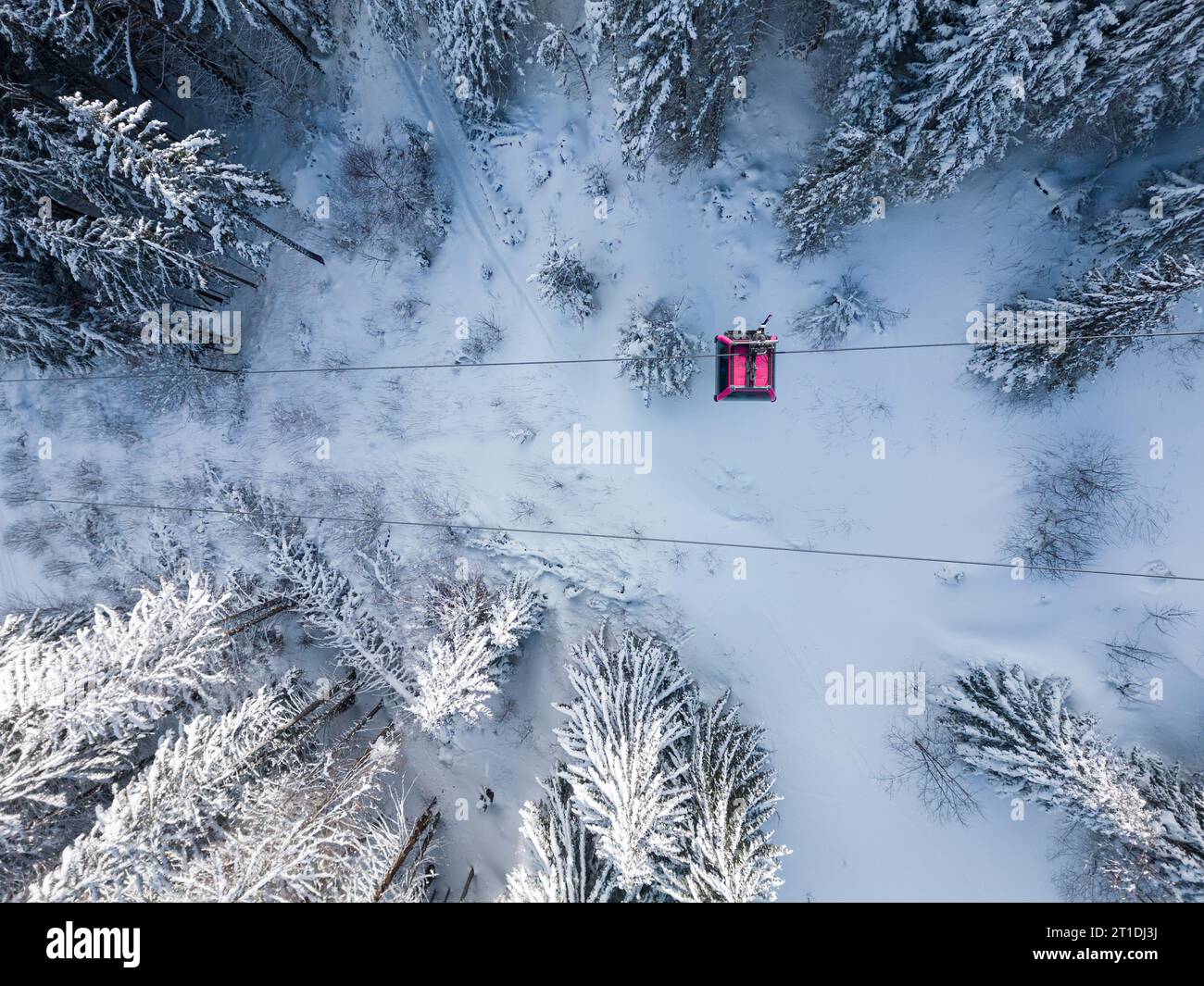 Aerial top down view of modern ski lift gondola against snowcovered fir ...
