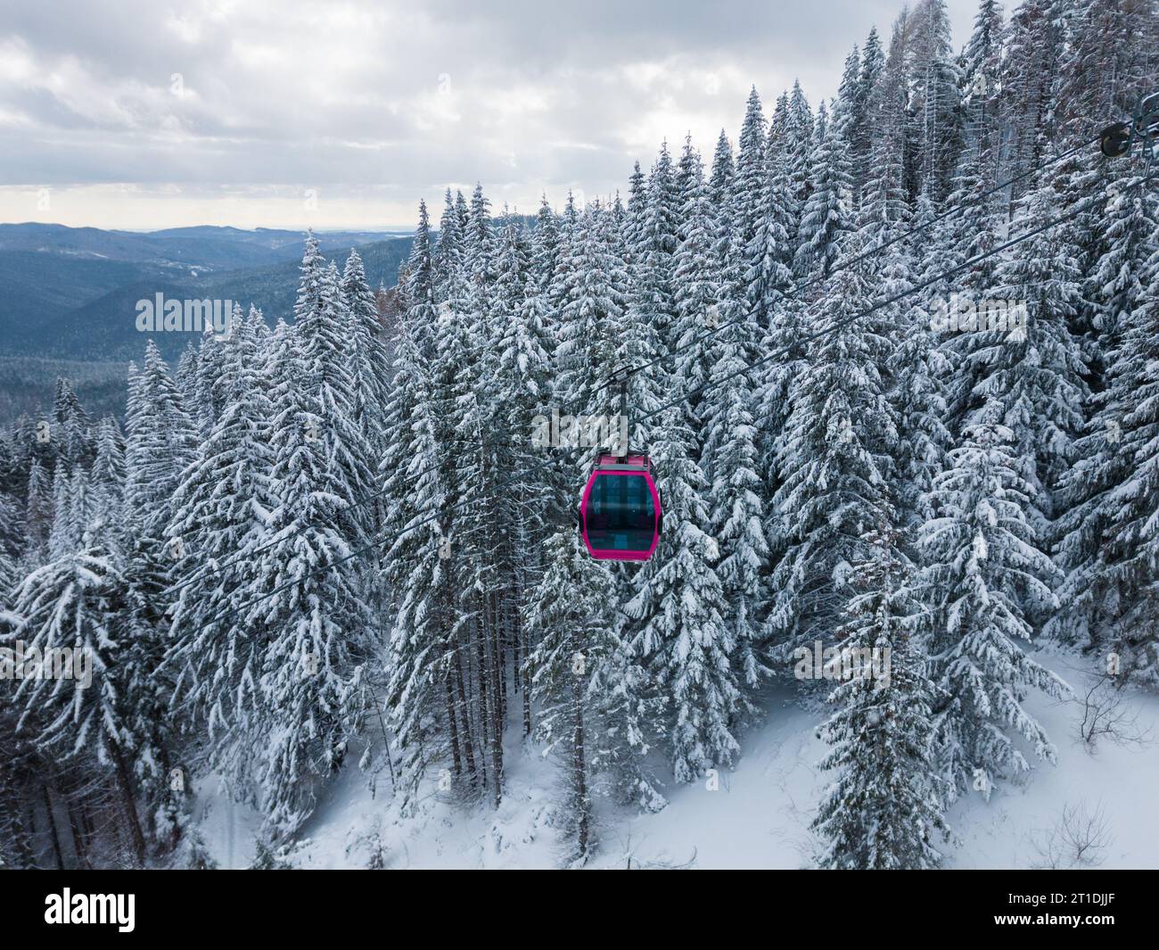 Modern ski lift gondola against snowcovered fir forest and mountains ...