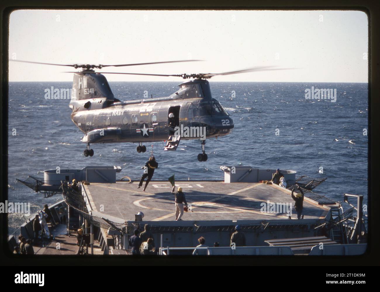 A Navy helicopter and a Navy ship, each in motion, do a drill of ...