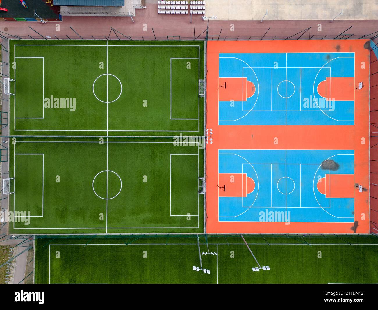 aerial view of a green football field and a colorful basketball court ...