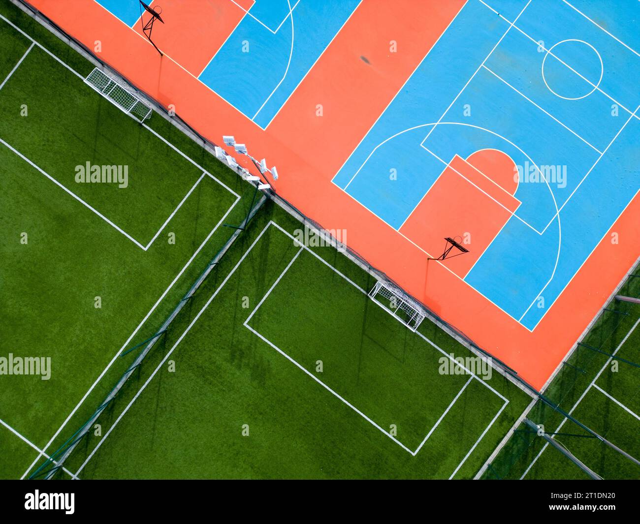 aerial view of a green football field and a colorful basketball court ...