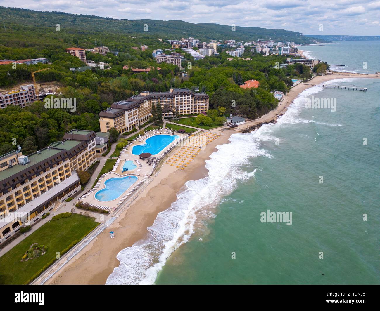 A breathtaking aerial view of a luxurious hotel with a seafront pool ...