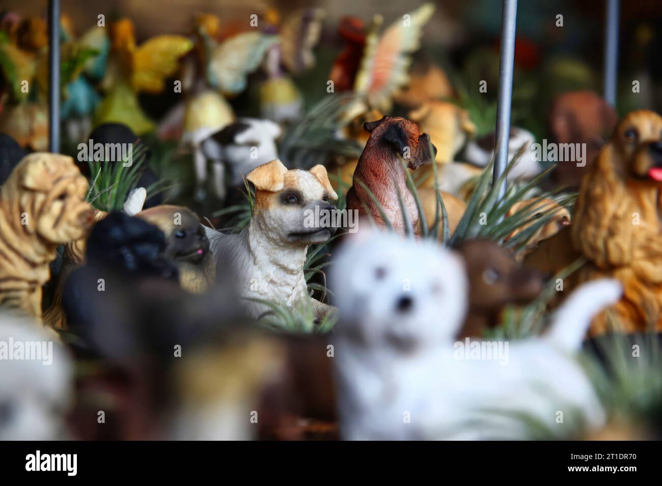 A group of dog figurines sitting in the grass. The figurines are made ...