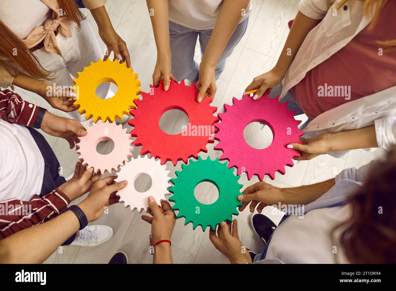 Team of school, college or university students connecting colorful cog ...