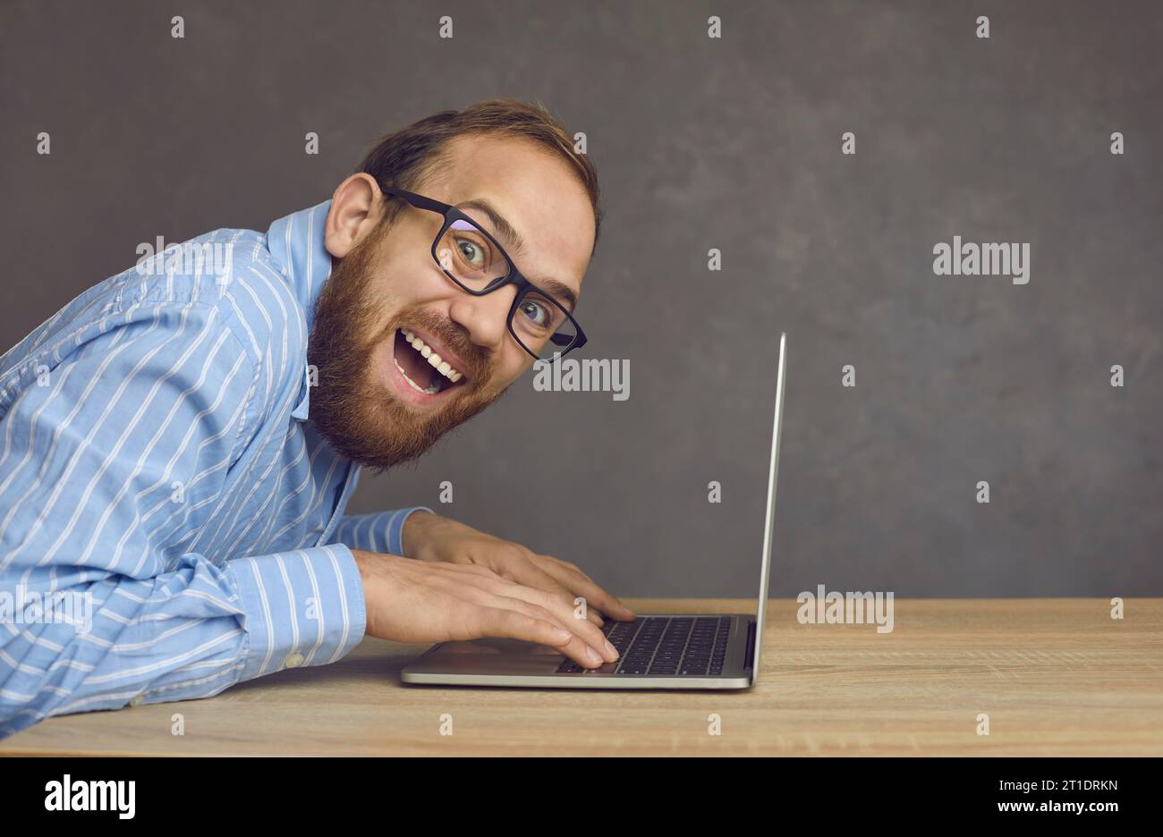 Side view portrait of a joyful crazy hacker or programmer sitting at a ...