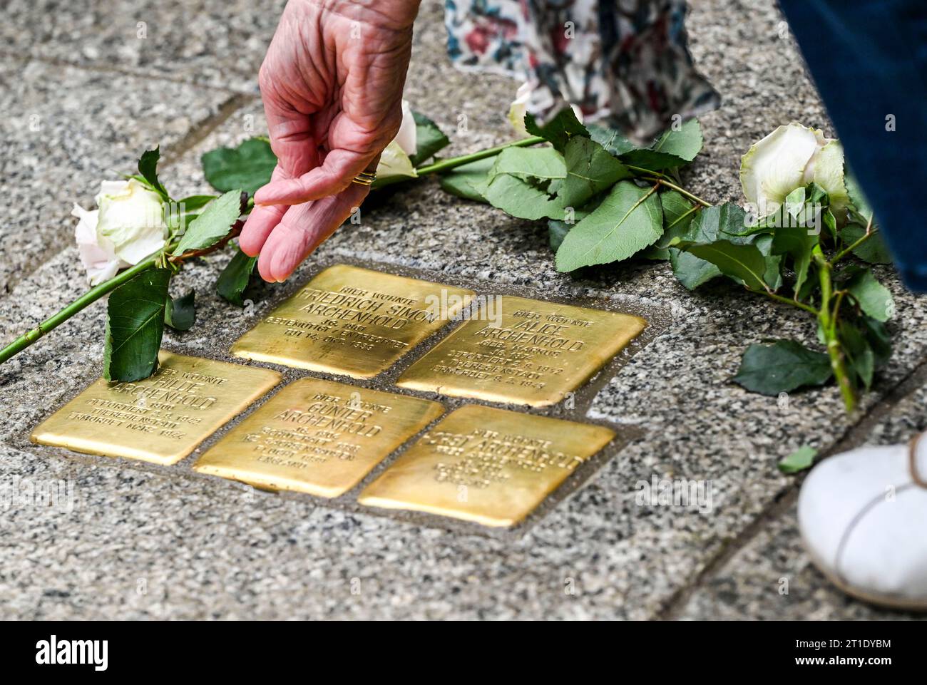 Berlin, Germany. 13th Oct, 2023. A woman lays a flower at the stumbling ...