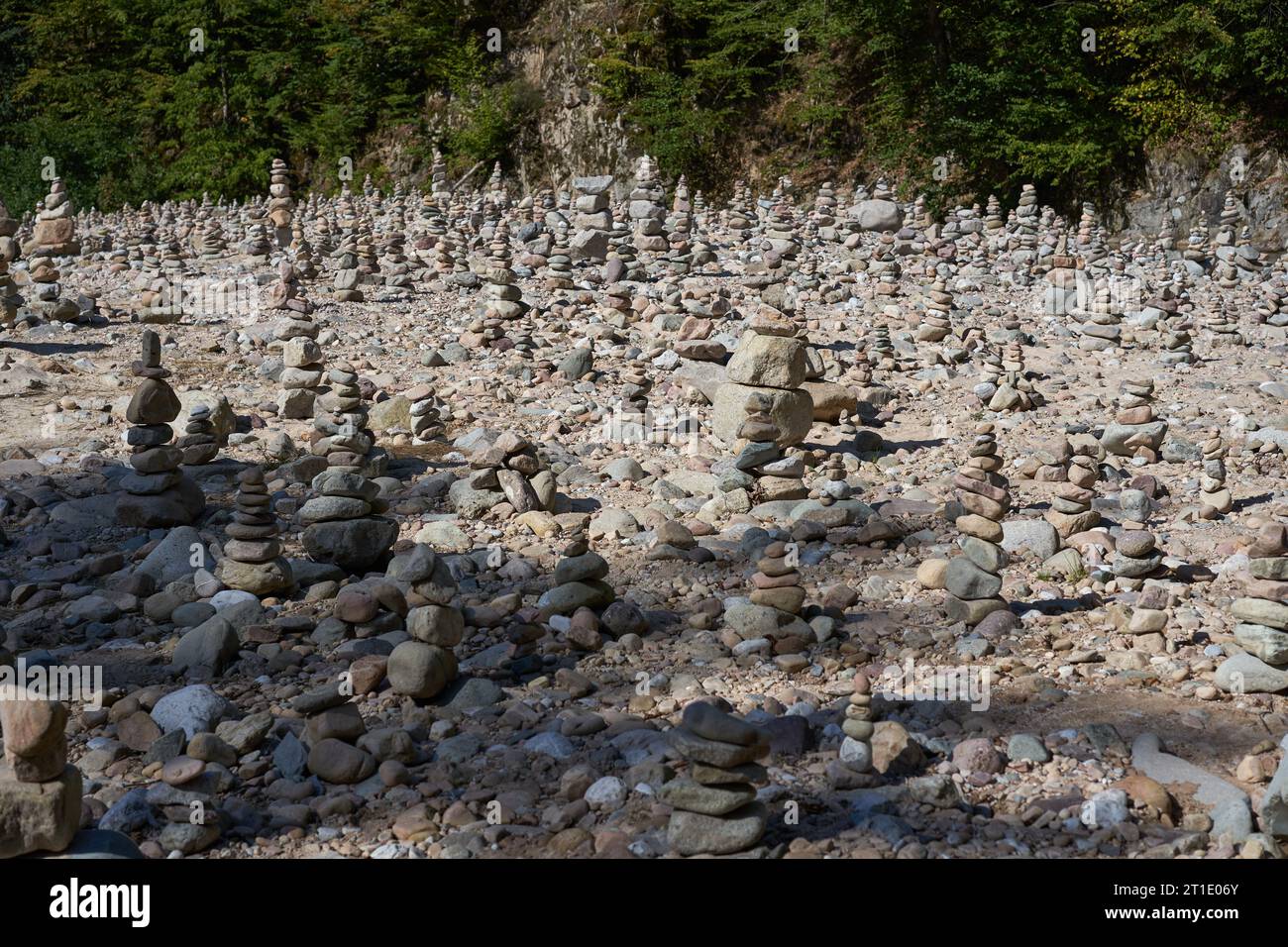 River pebbles and stones arranged in tower structures on the shore ...