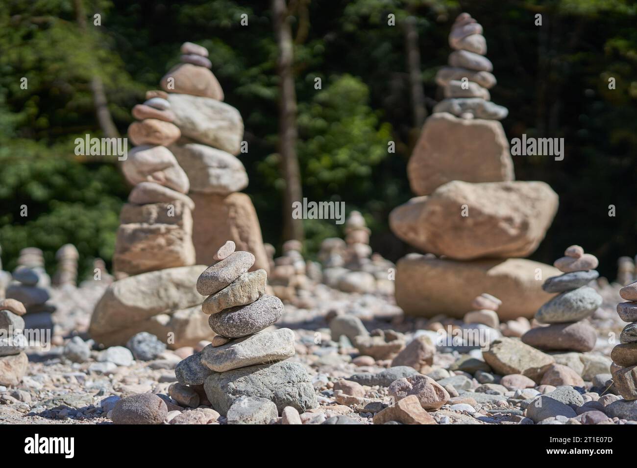 River pebbles and stones arranged in tower structures on the shore ...