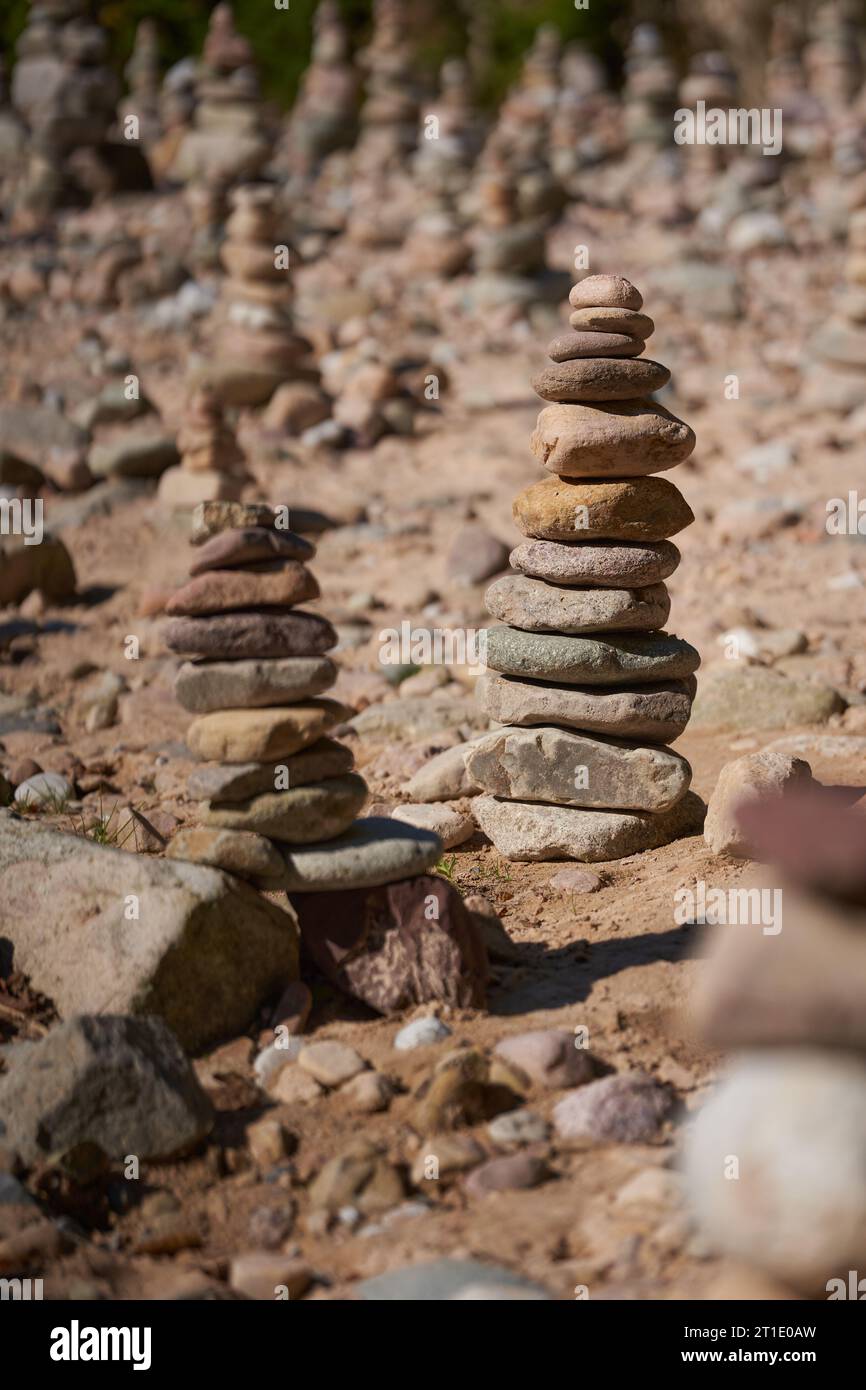 River pebbles and stones arranged in tower structures on the shore ...